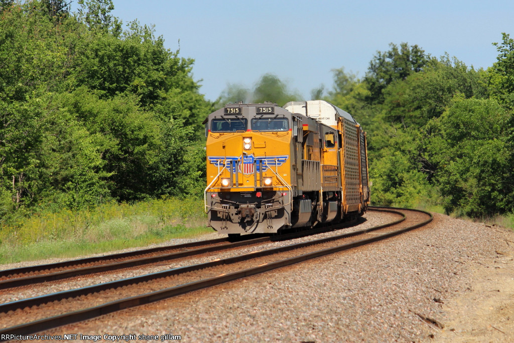 UP 7515 bring a wb auto rack train into view.